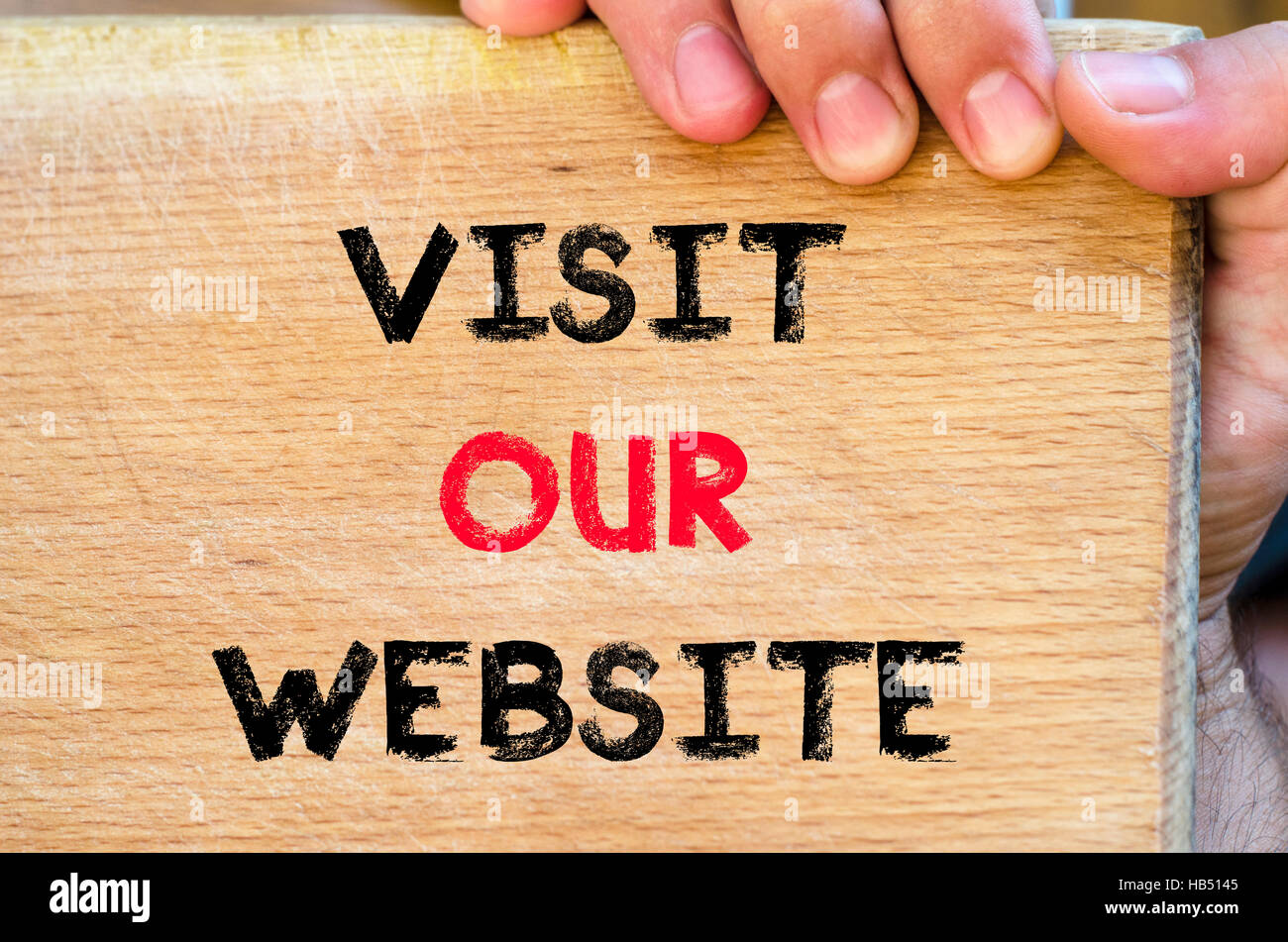 Human hand over wooden background and visit our website text concept ...