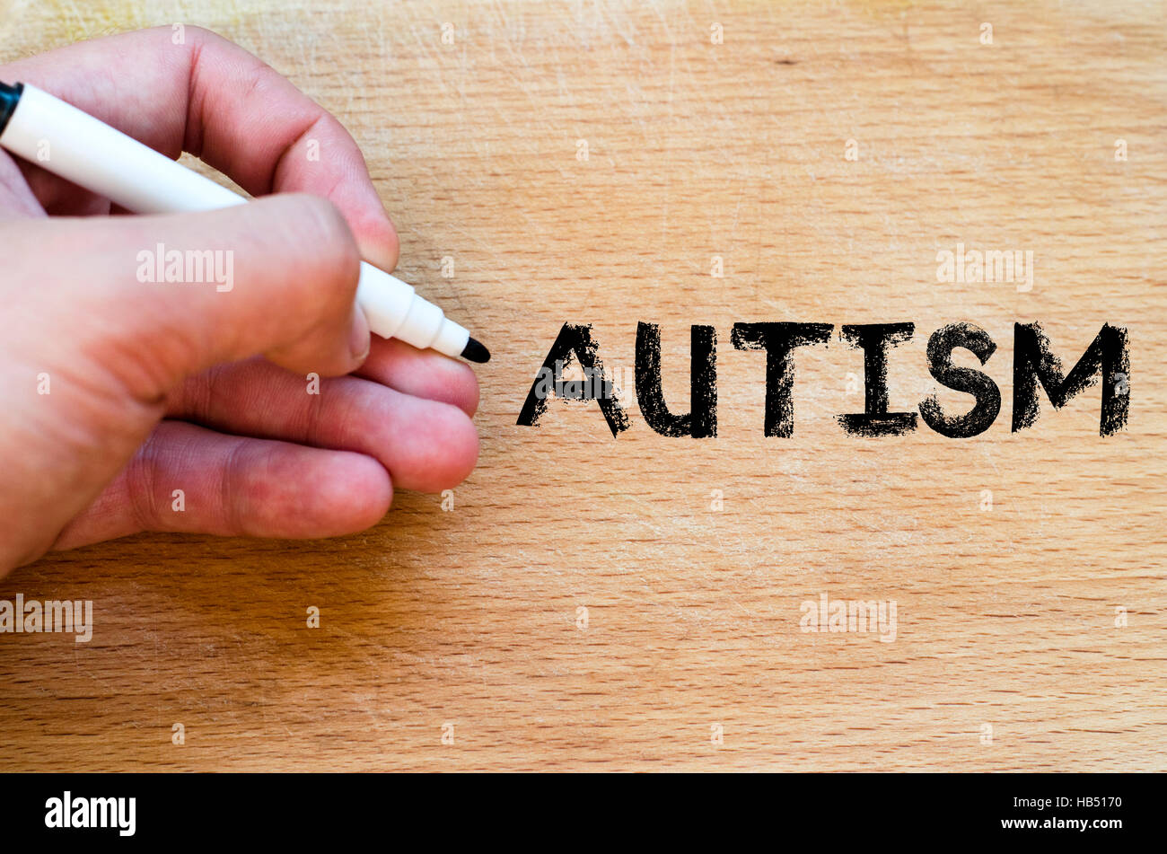 Human hand over wooden background and autism text concept Stock Photo ...