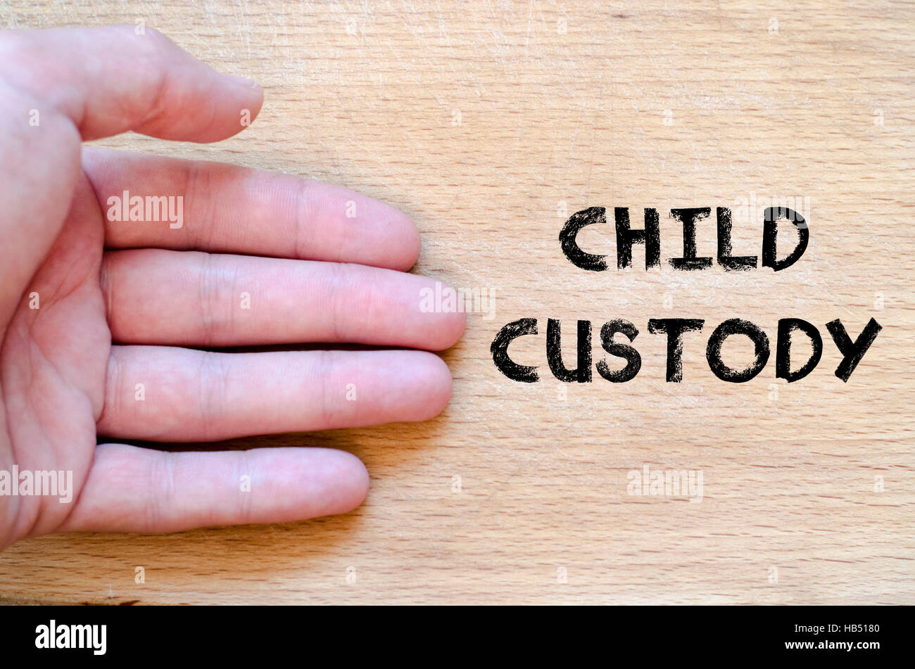 Human hand over wooden background and child custody text concept Stock ...
