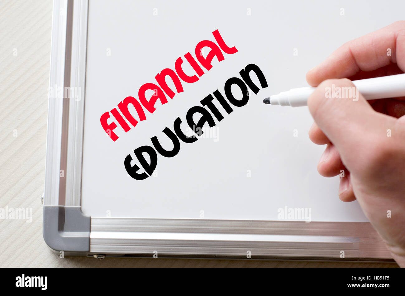 Human hand writing financial education on whiteboard Stock Photo - Alamy