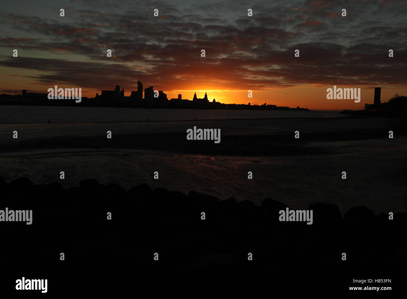 The sun rises behind the Liver Building over the Liverpool waterfront ...