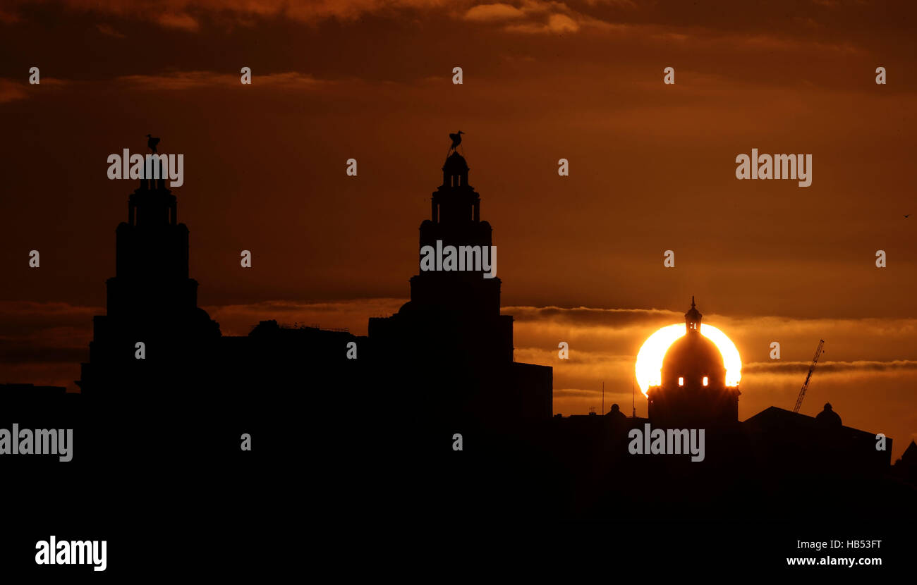 The sun rises behind the Liver Building over the Liverpool waterfront ...