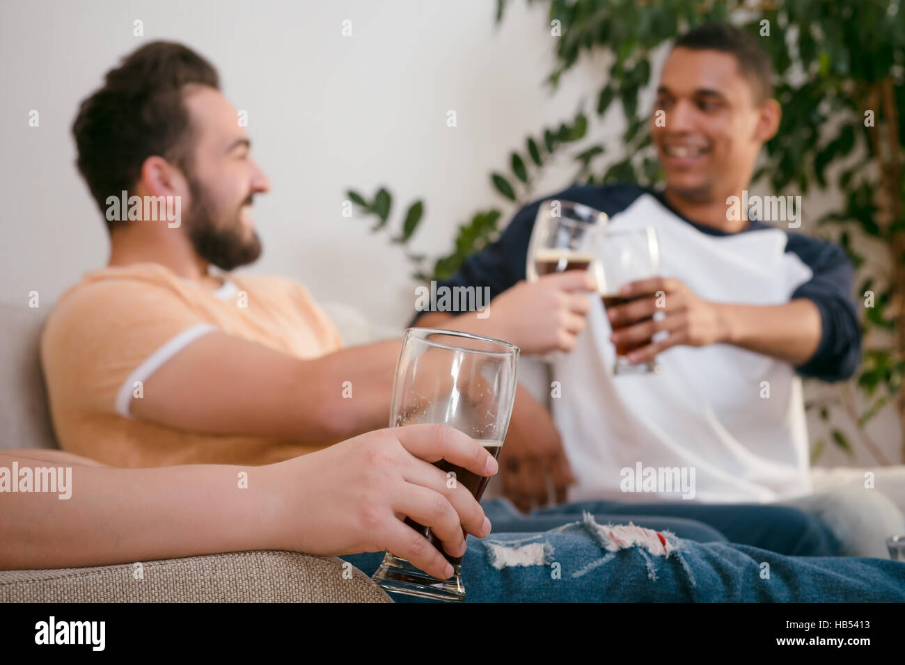 Happy friends drinking beer at home Stock Photo - Alamy