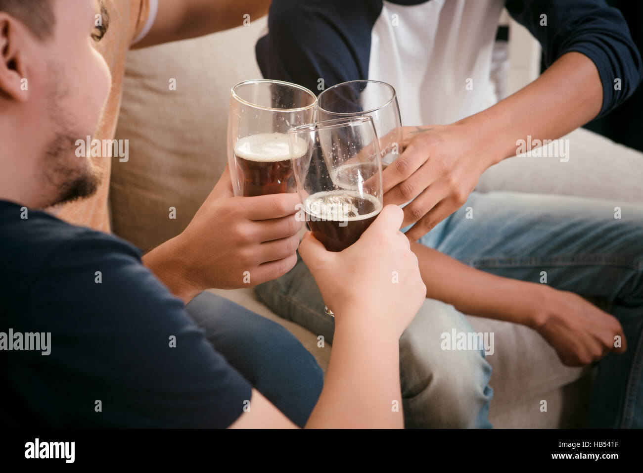 Happy friends drinking beer at home Stock Photo - Alamy