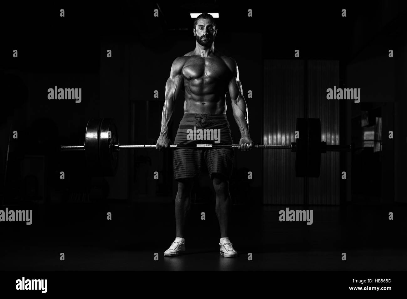 Latin Bodybuilder Doing Heavy Weight Exercise For Back With Barbell In ...