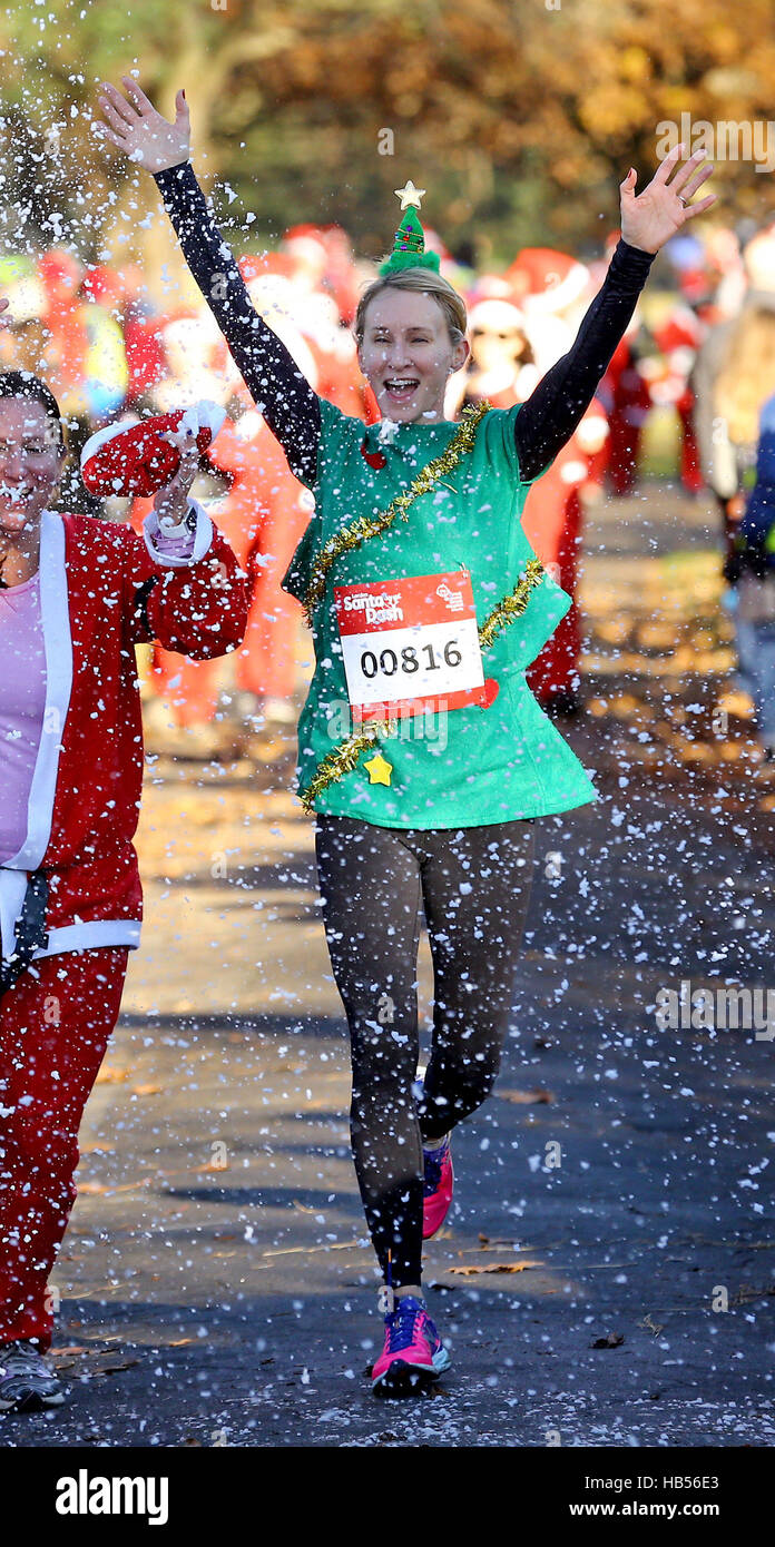 A runner finishes the London Santa Dash at Clapham Common, to raise ...