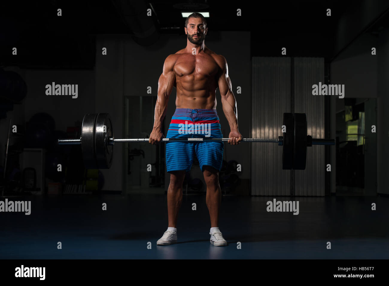 Latin Bodybuilder Doing Heavy Weight Exercise For Back With Barbell In ...