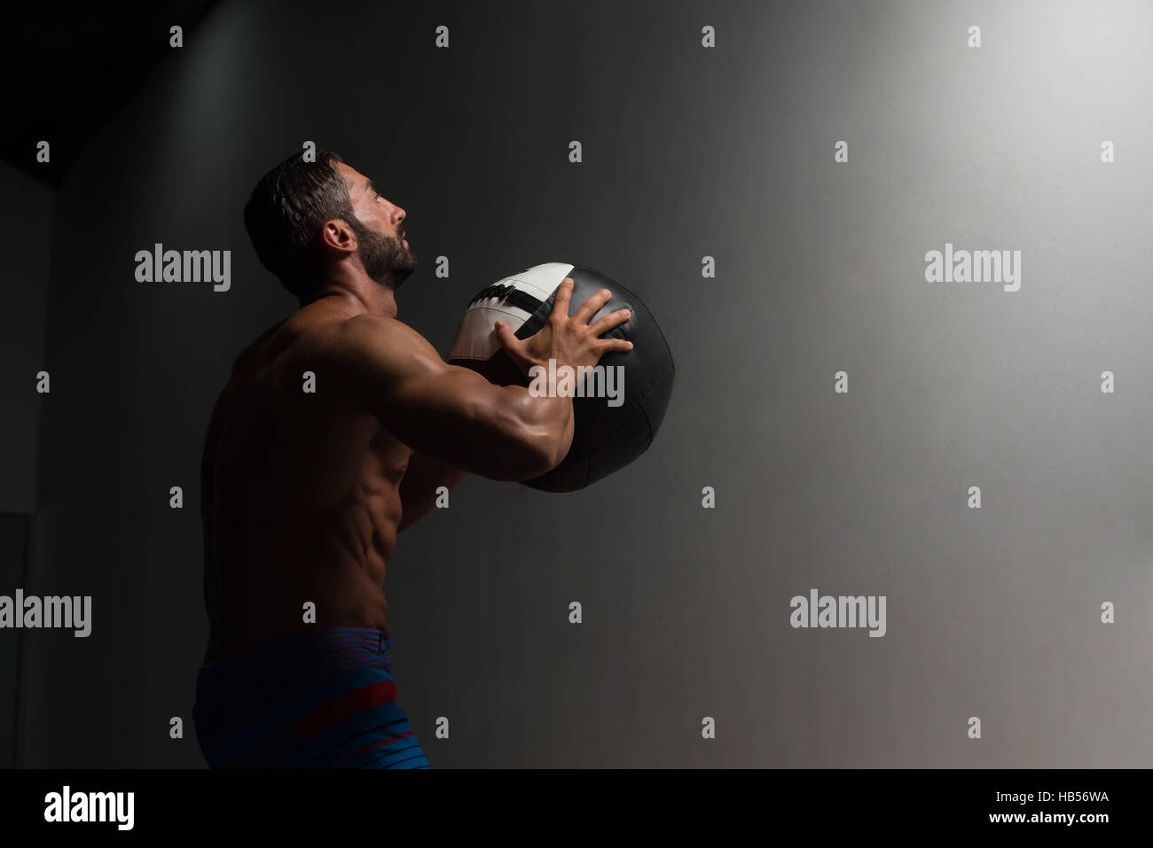 Latin Male Athlete Crouched Doing Wall Balls Exercises At The Gym Stock ...