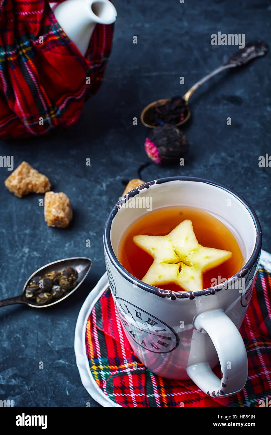 Cup of tea with apple star on slate blue background Stock Photo - Alamy