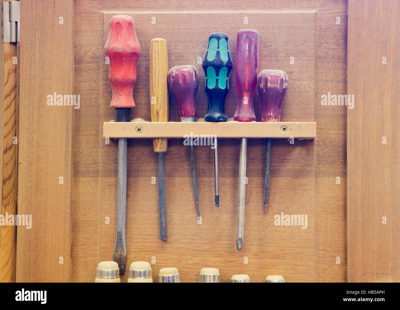 several screwdrivers hanging on wooden wall at workshop Stock Photo - Alamy