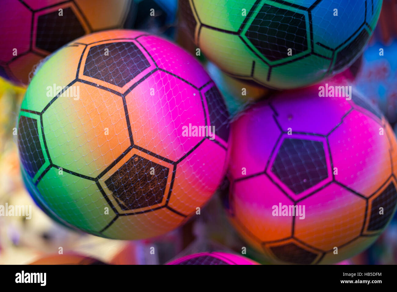 Multi-coloured footballs in a plastic mesh net Stock Photo - Alamy