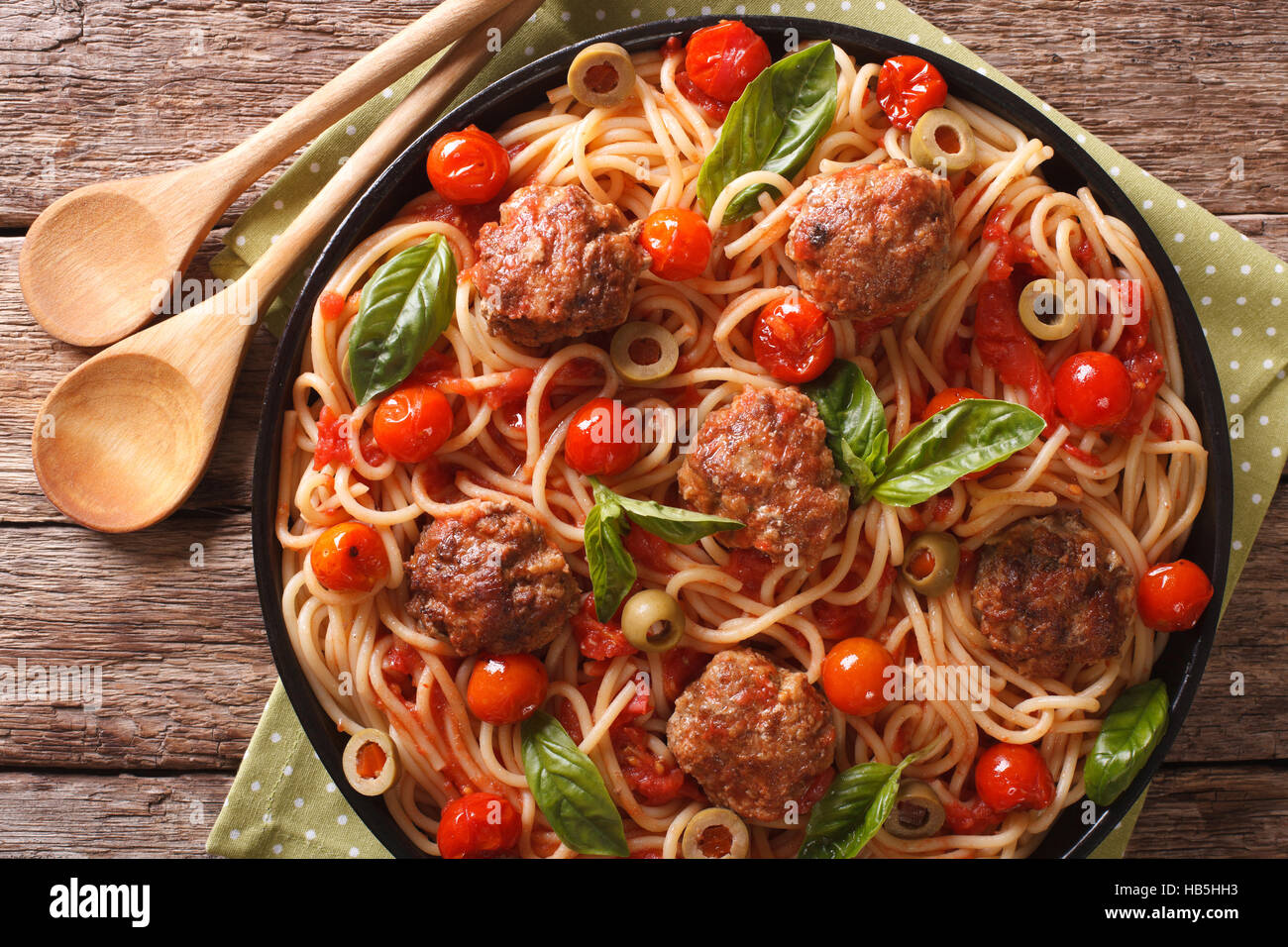 Pasta spaghetti with meatballs, olives and tomatoes close-up on the ...