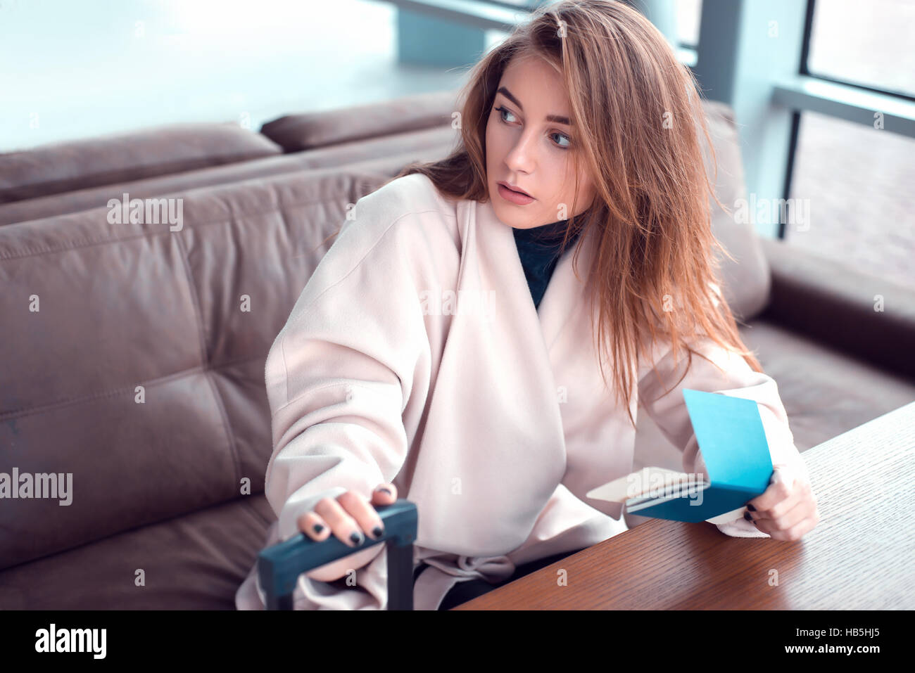 Woman sitting on the couch in a hall Stock Photo - Alamy