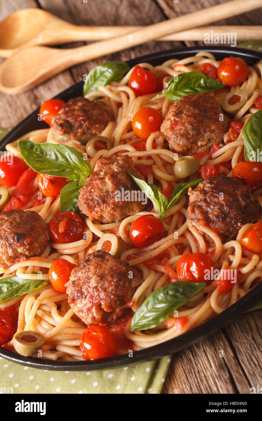 Pasta spaghetti with meatballs, olives and tomatoes close-up on the ...