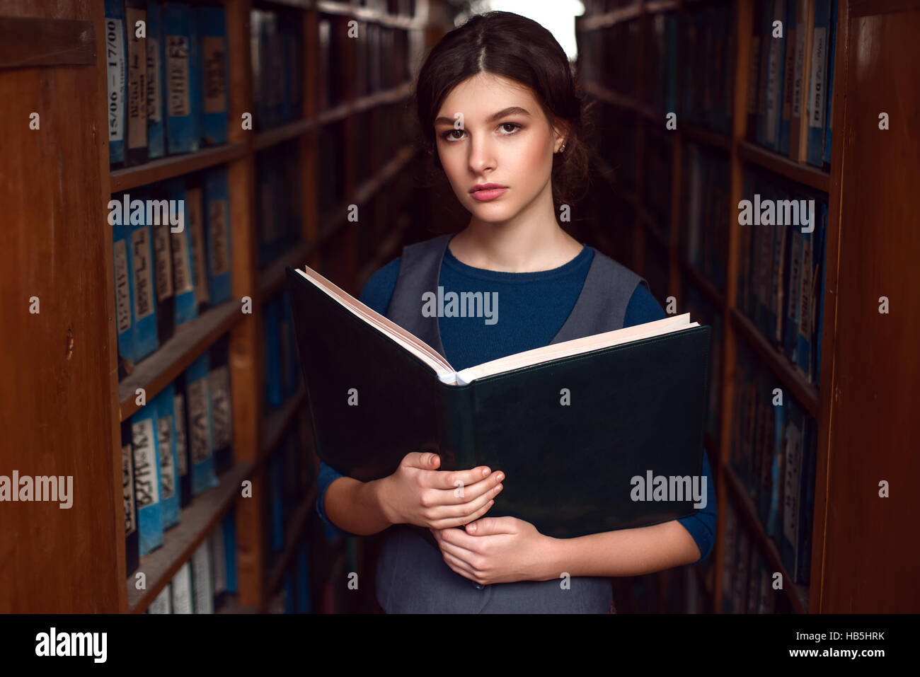 Student with open book in college library Stock Photo - Alamy