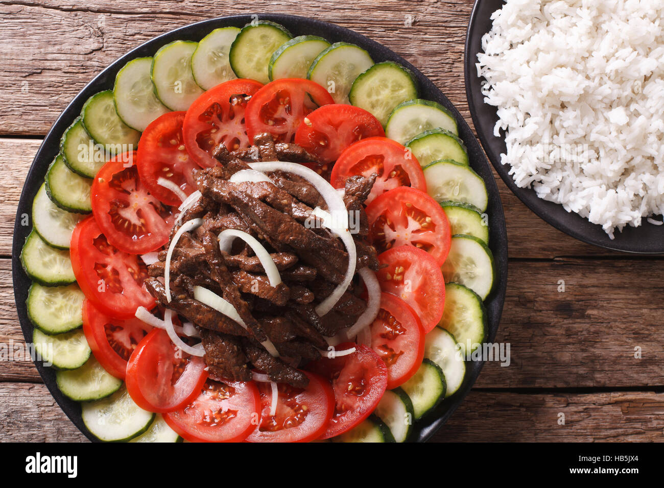 Cambodian cuisine: Beef Lok Lak with fresh vegetables close-up on a ...