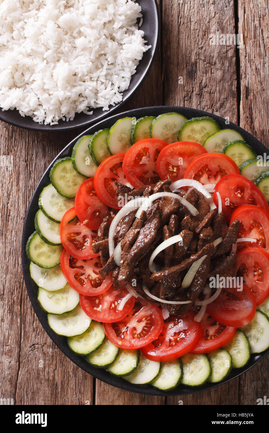 Cambodian cuisine: Beef Lok Lak with fresh vegetables close-up on a ...