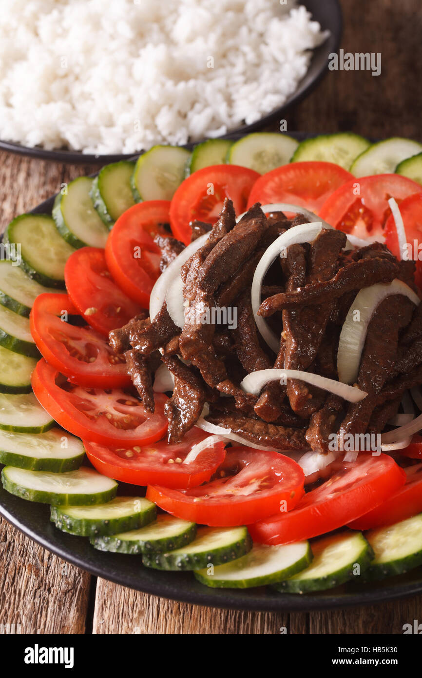 Cambodian food: beef Lok Lak with fresh tomatoes and cucumbers close-up ...