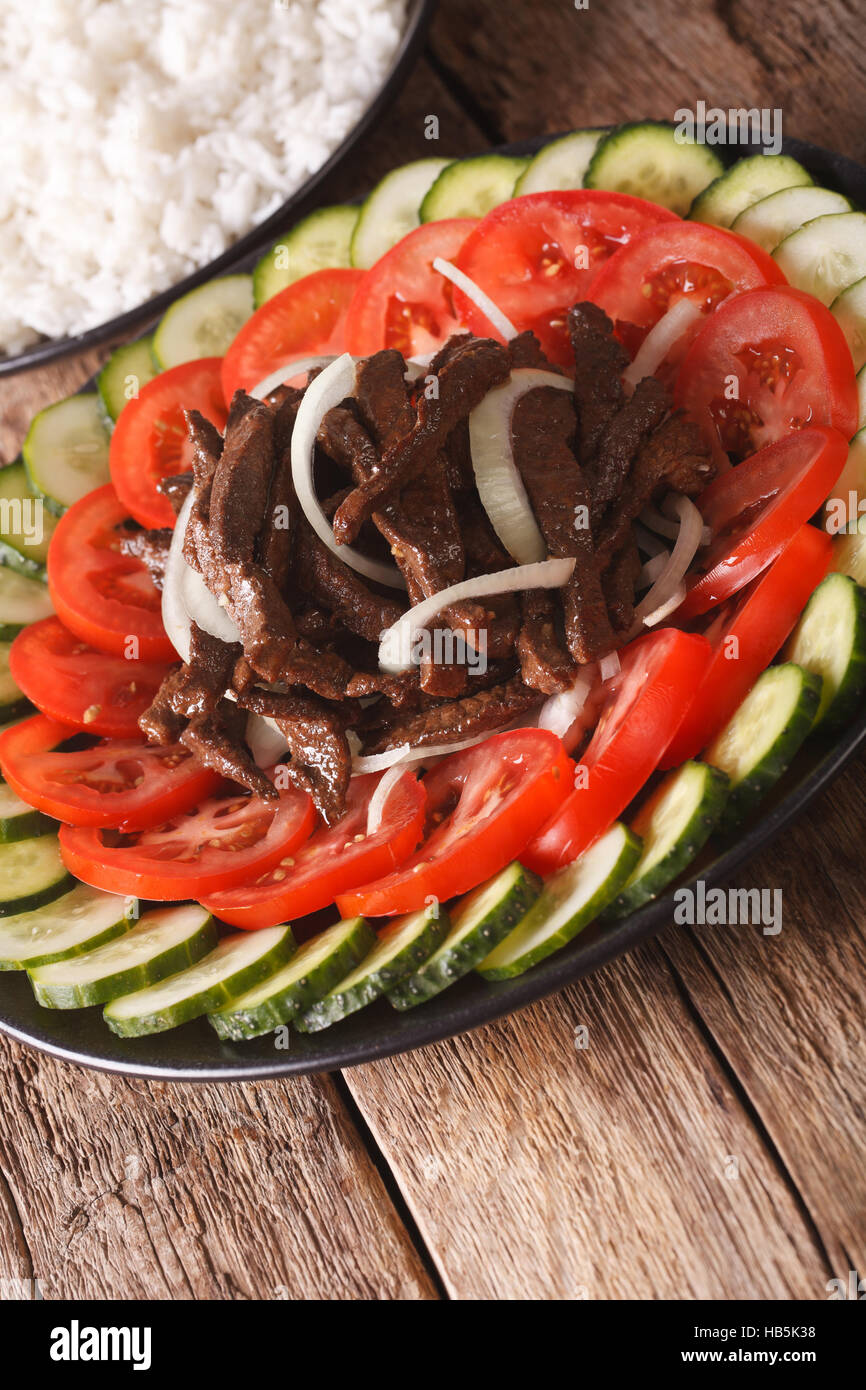 Cambodian beef Lok Lak with fresh vegetables close-up on a plate ...