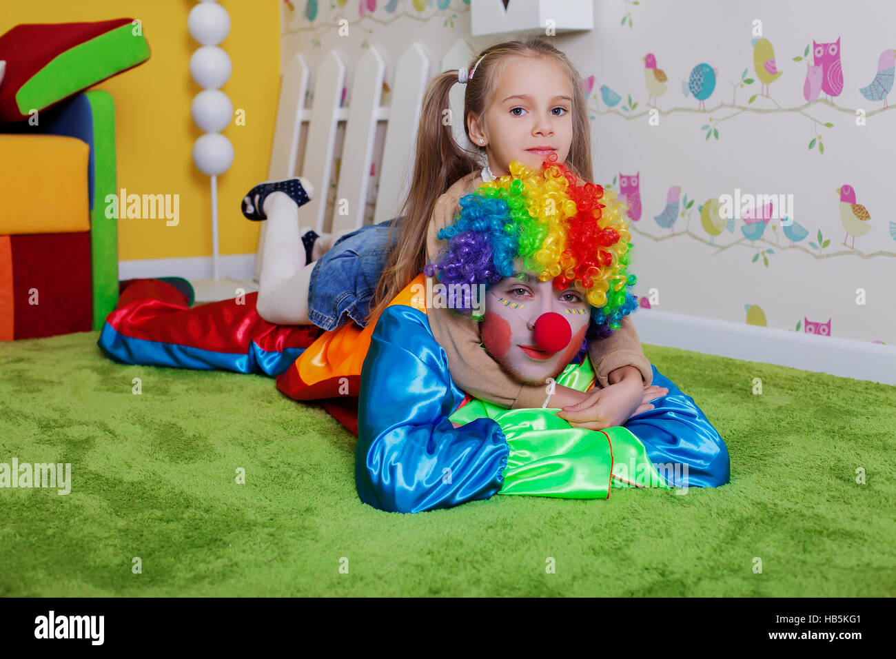 Girl sits on a back of the clown Stock Photo - Alamy