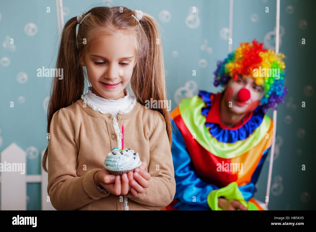 Little girl holds cake in hand and makes a wish Stock Photo - Alamy