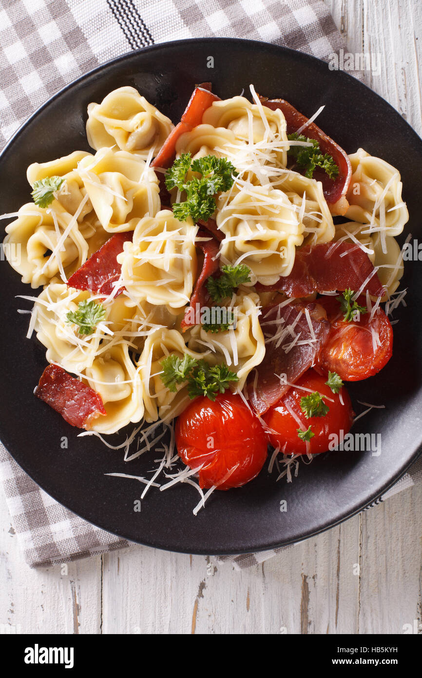 Freshly cooked tortellini with prosciutto and parmesan close-up on a ...