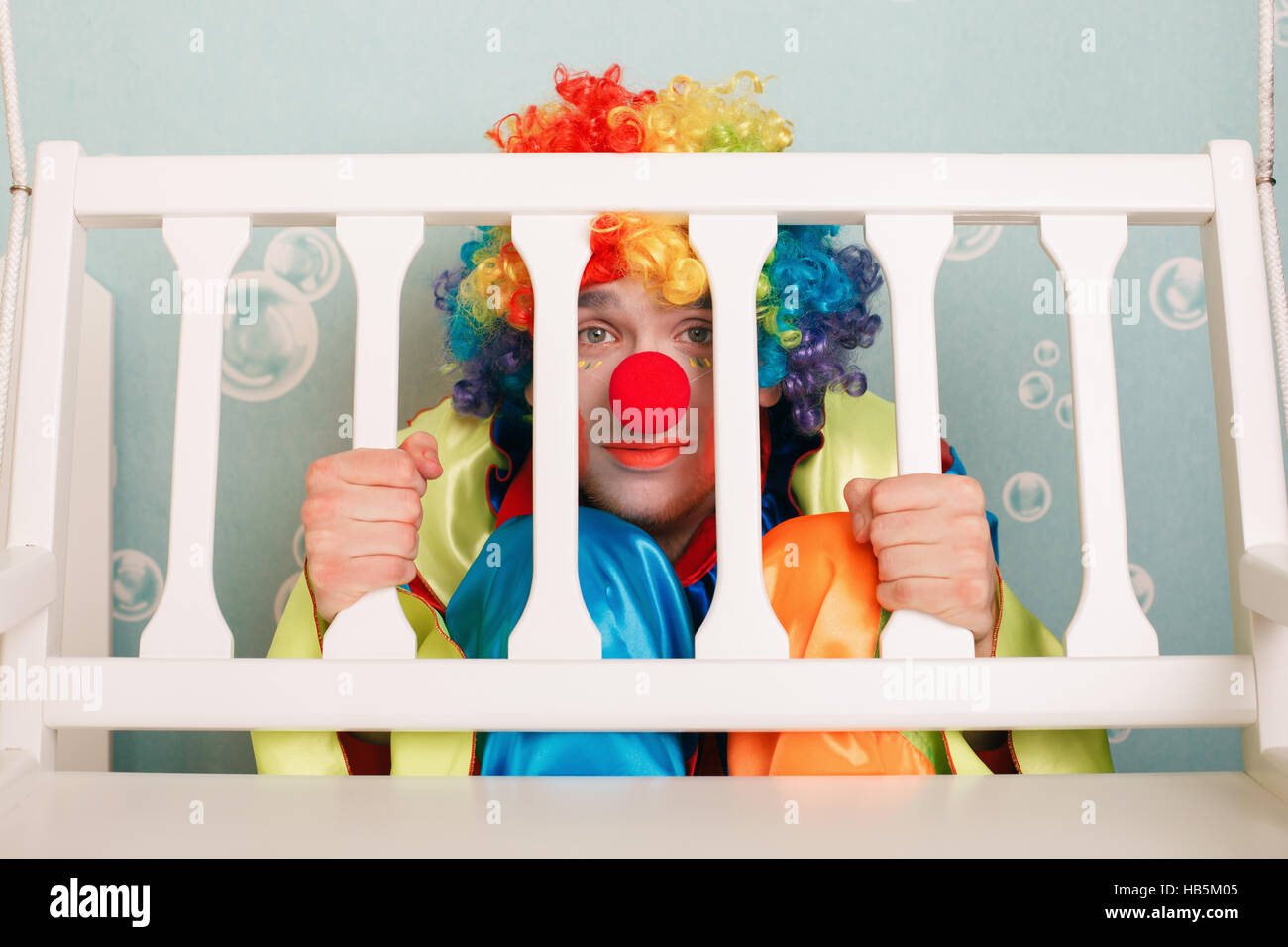 Punished clown sits under a bench Stock Photo - Alamy