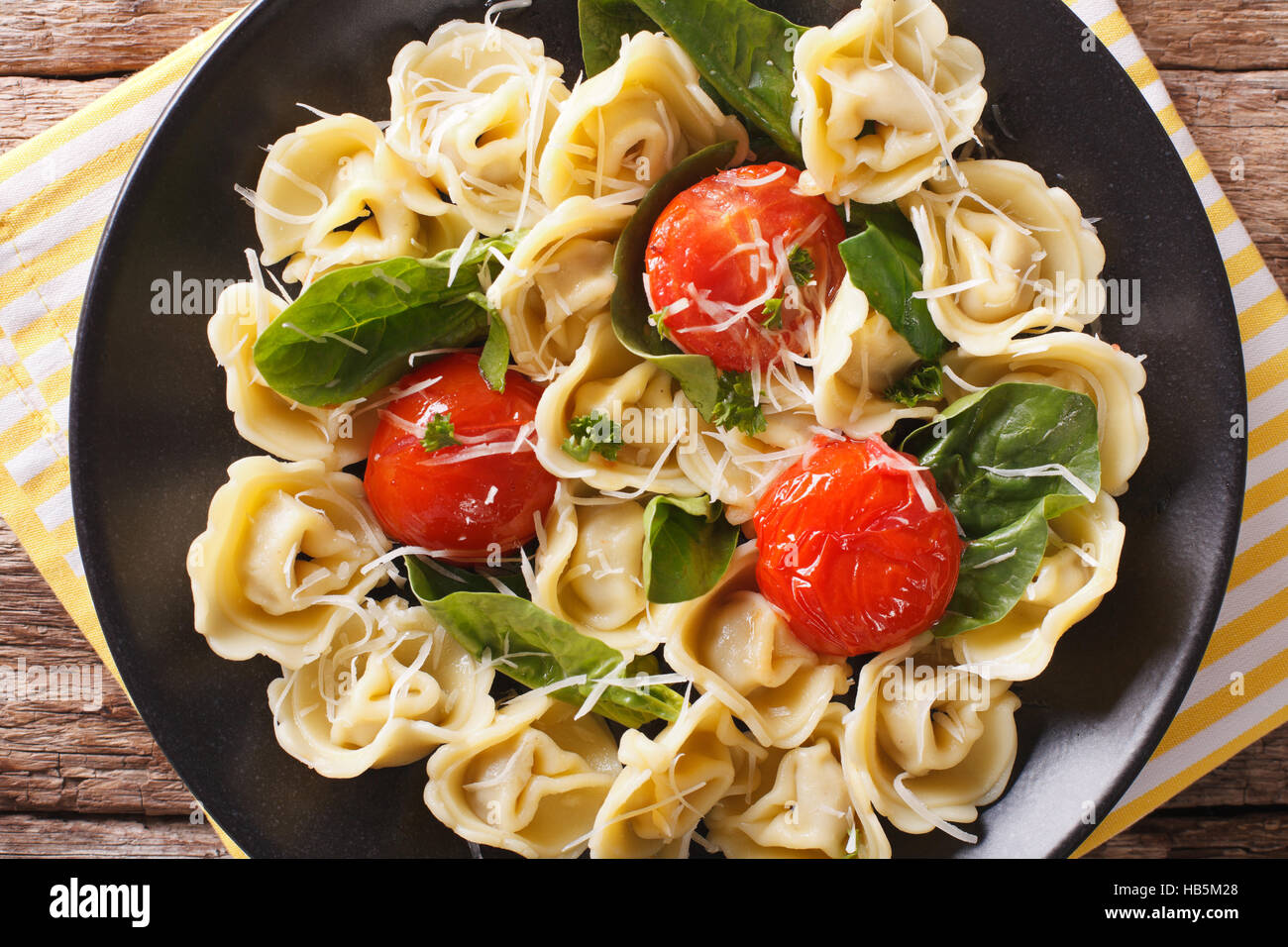 Italian food: tortellini with spinach and parmesan close-up on a plate ...
