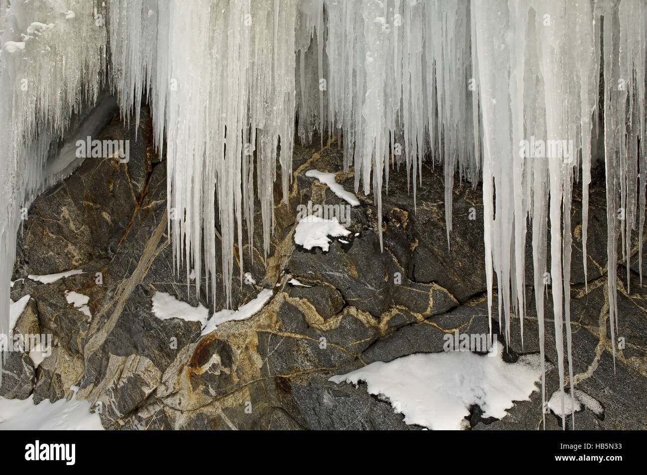 Huge icicles on rocks Stock Photo - Alamy