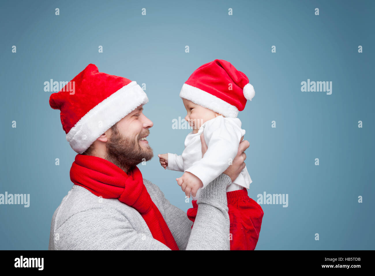 Father with his baby boy wearing Santa hats celebrating Christmas Stock ...