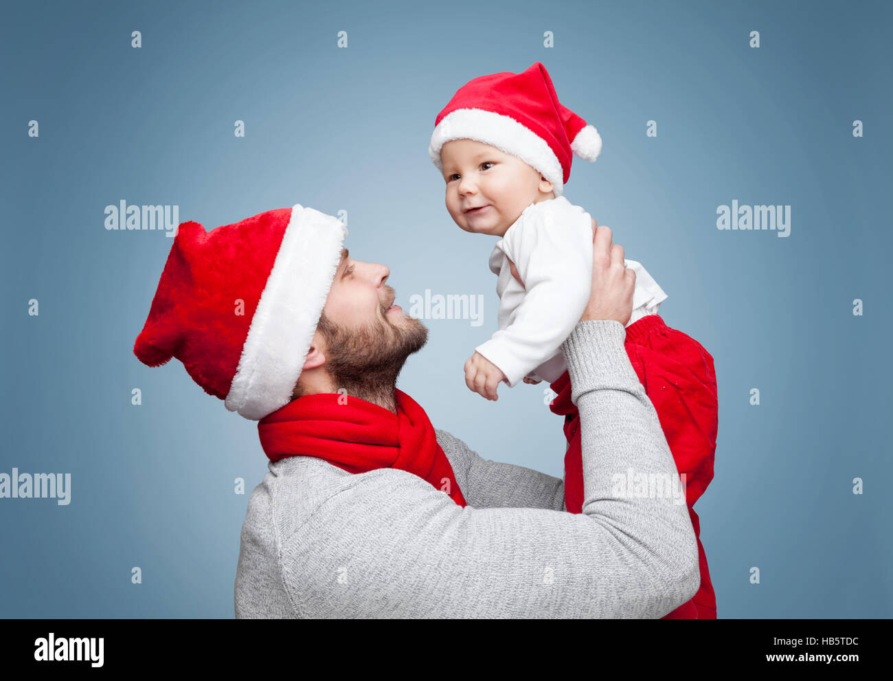Father with his baby boy wearing Santa hats celebrating Christmas Stock ...