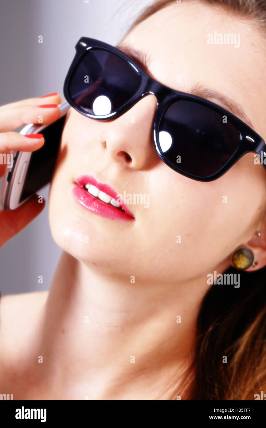 Young female with sunglasses and smartphone Stock Photo - Alamy