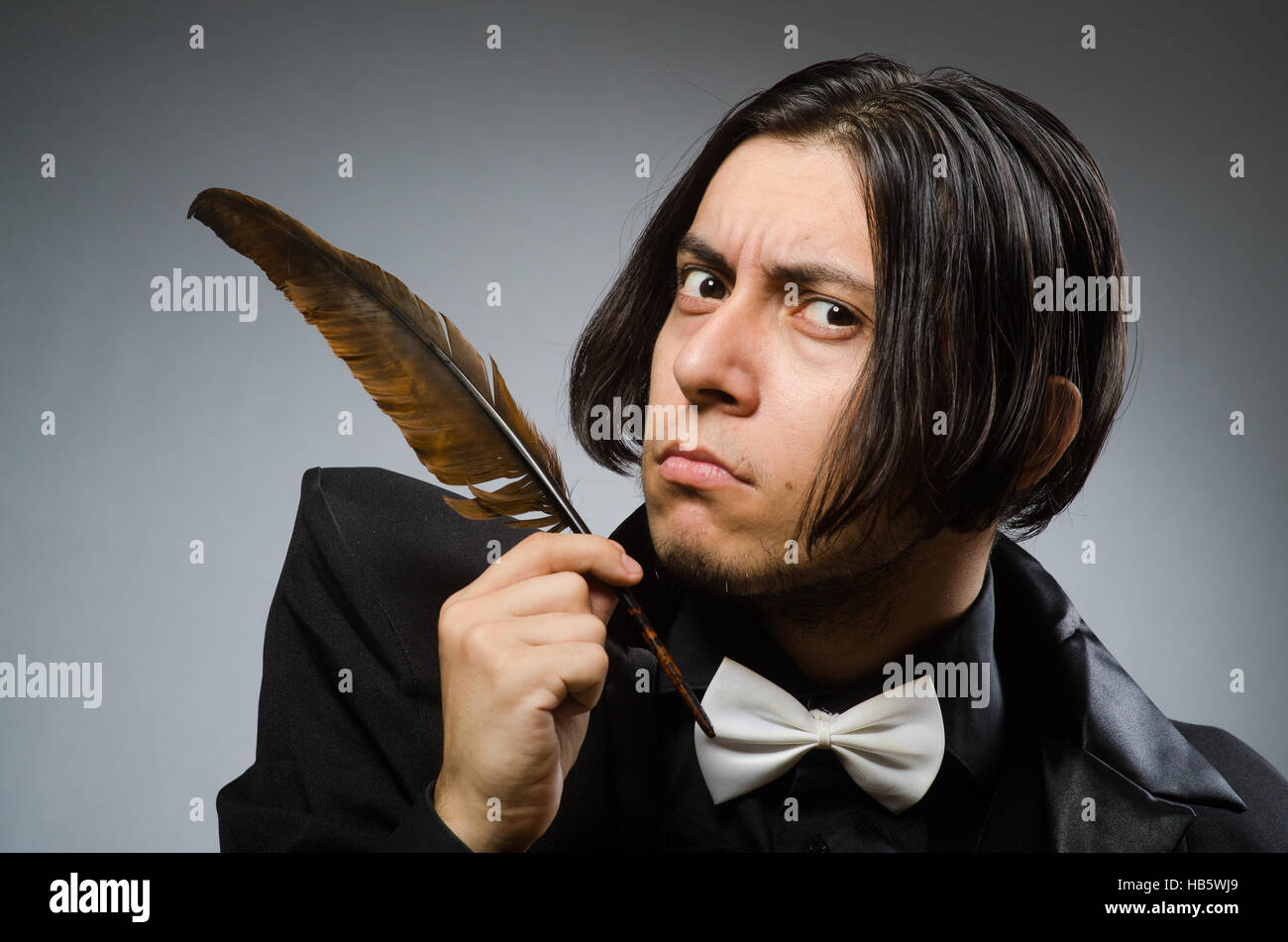 Young man with writing feather Stock Photo - Alamy