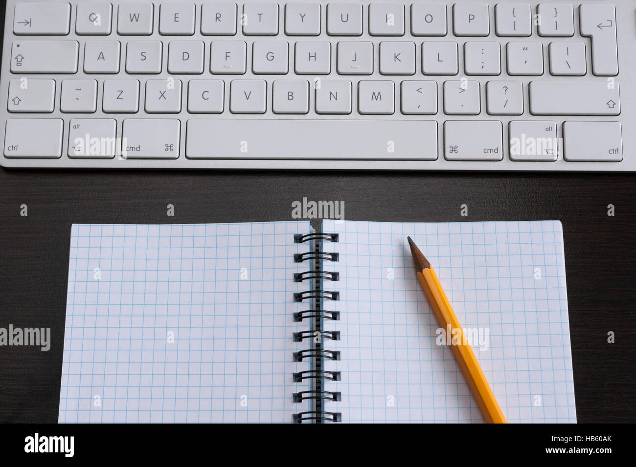Notebook and pencil on the desk next to the computer keyboard Stock ...
