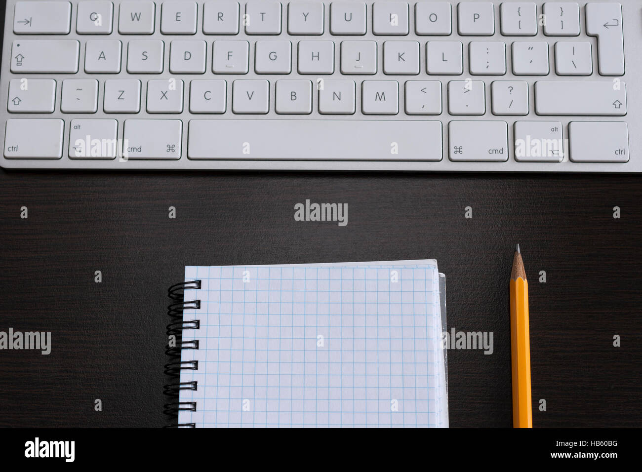Notebook and pencil on the desk next to the computer keyboard Stock ...