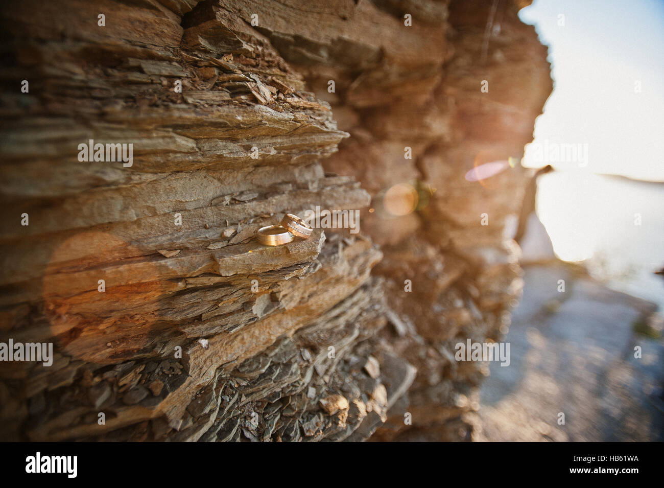 Wedding rings on stone of rock on sunset Stock Photo - Alamy