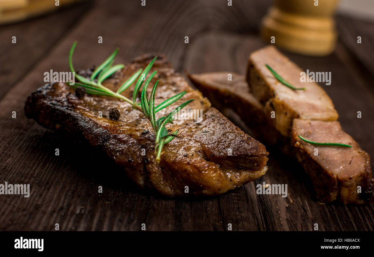 Grilled pork neck steak with rosemary on wood table Stock Photo - Alamy