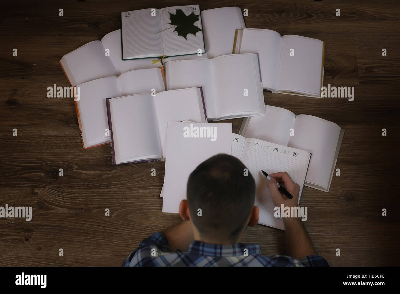 man working with book on the floor Stock Photo - Alamy