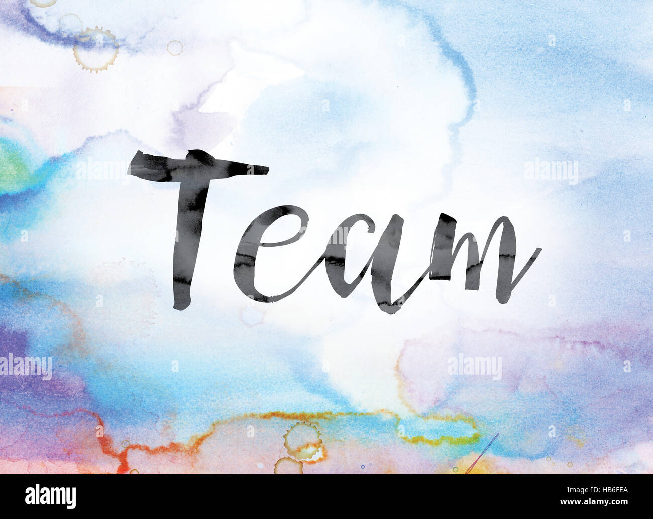 The word "Team" painted in black ink over a colorful watercolor washed ...