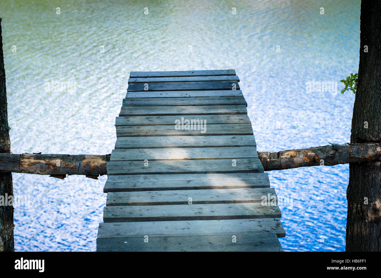 rural wooden footbridge and blue lake surface Stock Photo - Alamy