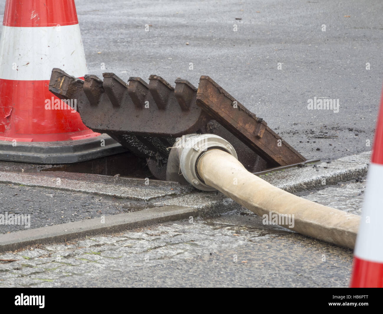 Gully cover with fire hose and Pylon Stock Photo - Alamy