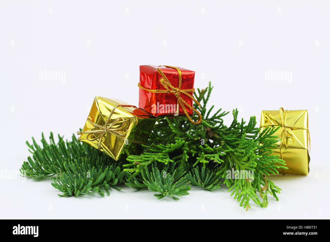 Three golden, red shiny Christmas presents on fresh pine with copy ...