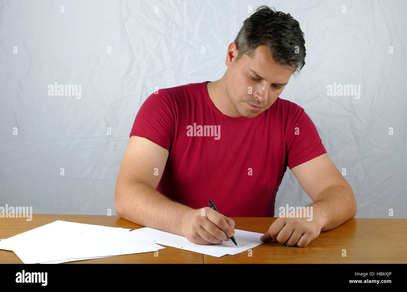 Young man writing on a paper Stock Photo - Alamy