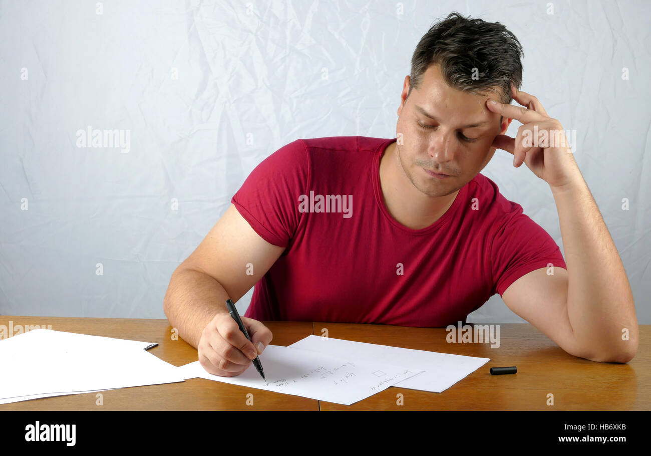Young man writing on a paper Stock Photo - Alamy