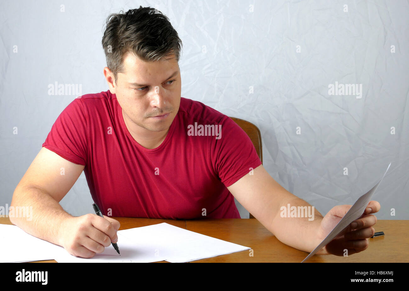 Young man writing on a paper Stock Photo - Alamy