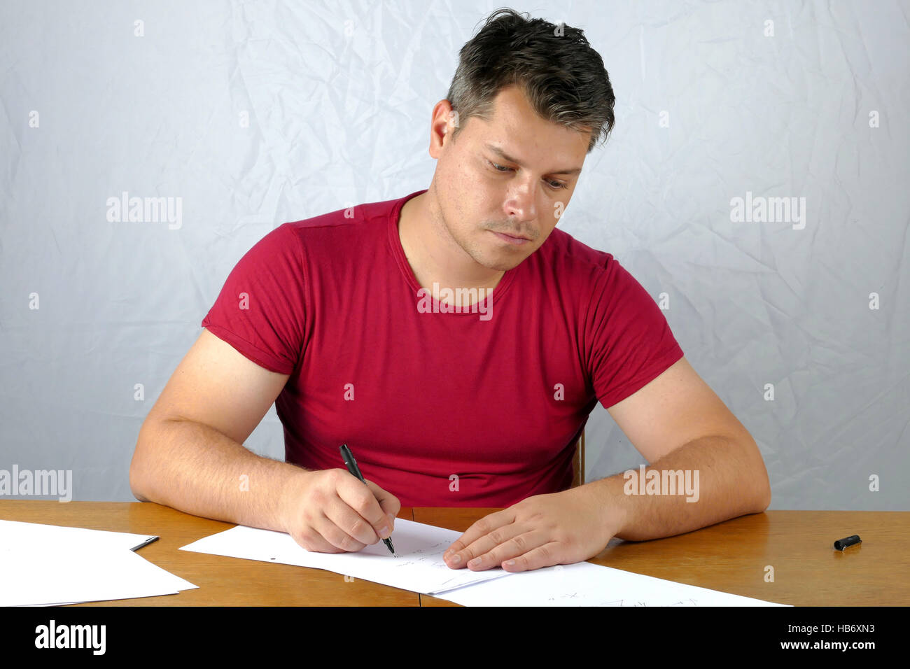 Young man writing on a paper Stock Photo - Alamy