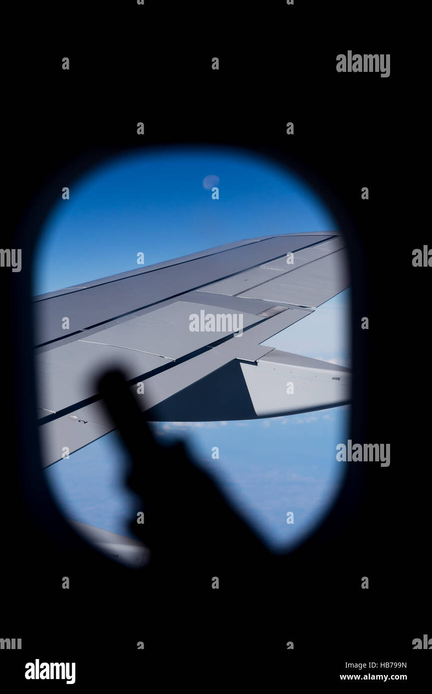 Reading tablet in airplane on way to vacation Stock Photo - Alamy