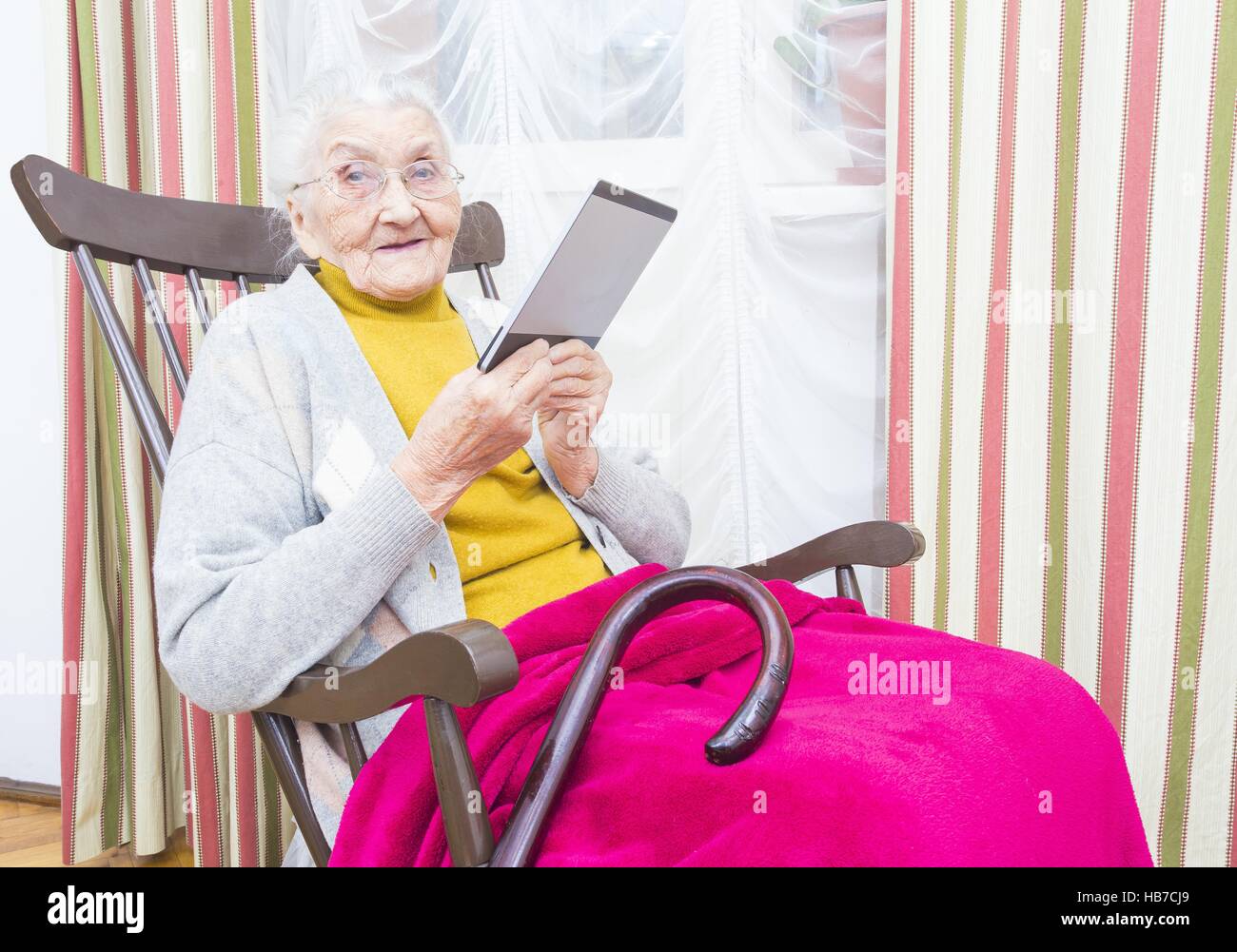 Elderly lady sitting in a nursing home and reading Stock Photo - Alamy