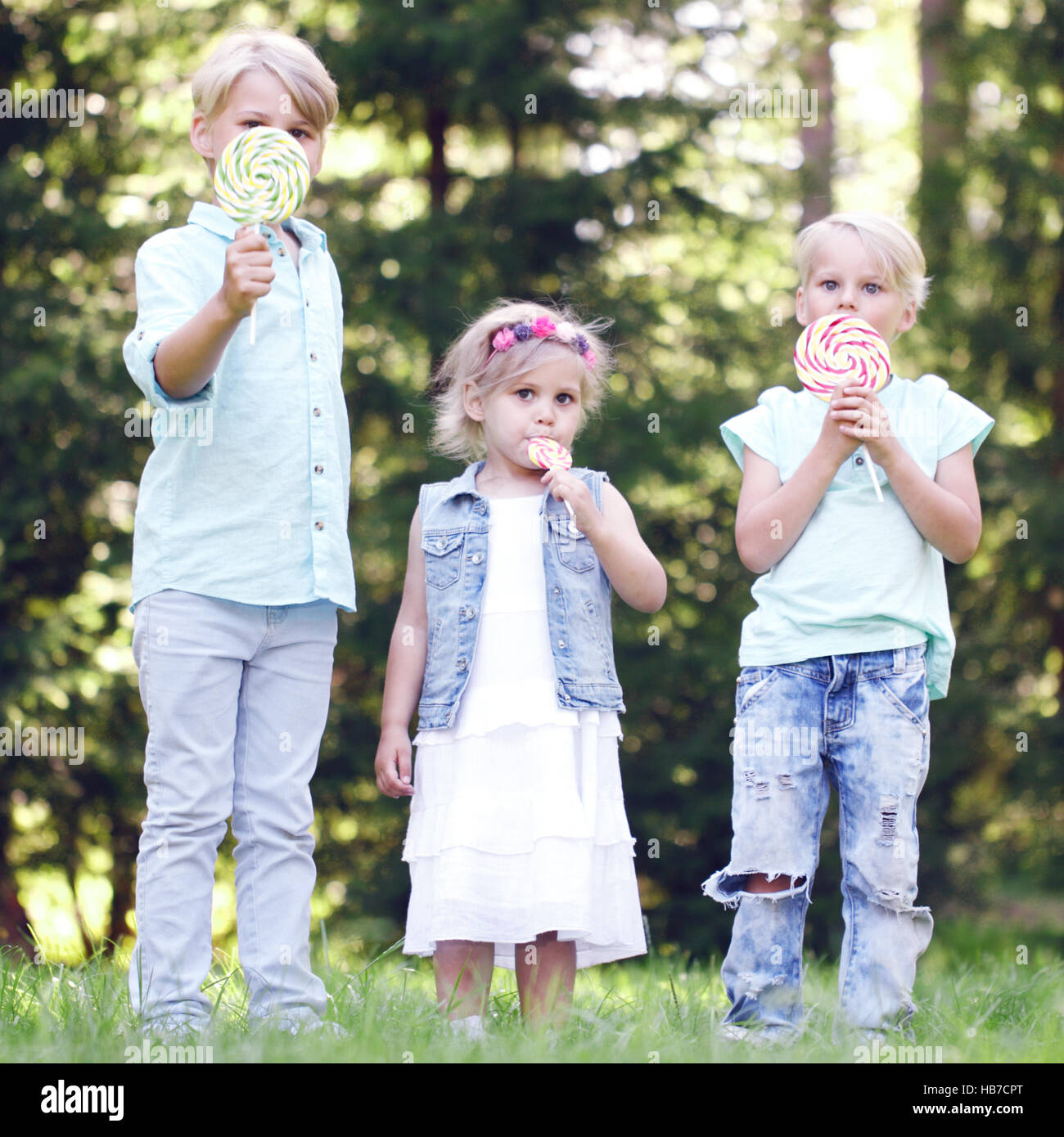Group of happy children eating lollipops outdoors in summer park Stock ...