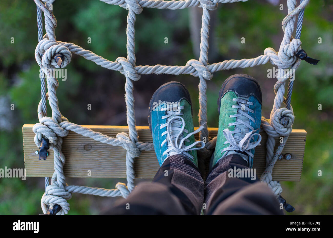 outdoor shoes on a rope grid , in an adventure park Stock Photo - Alamy